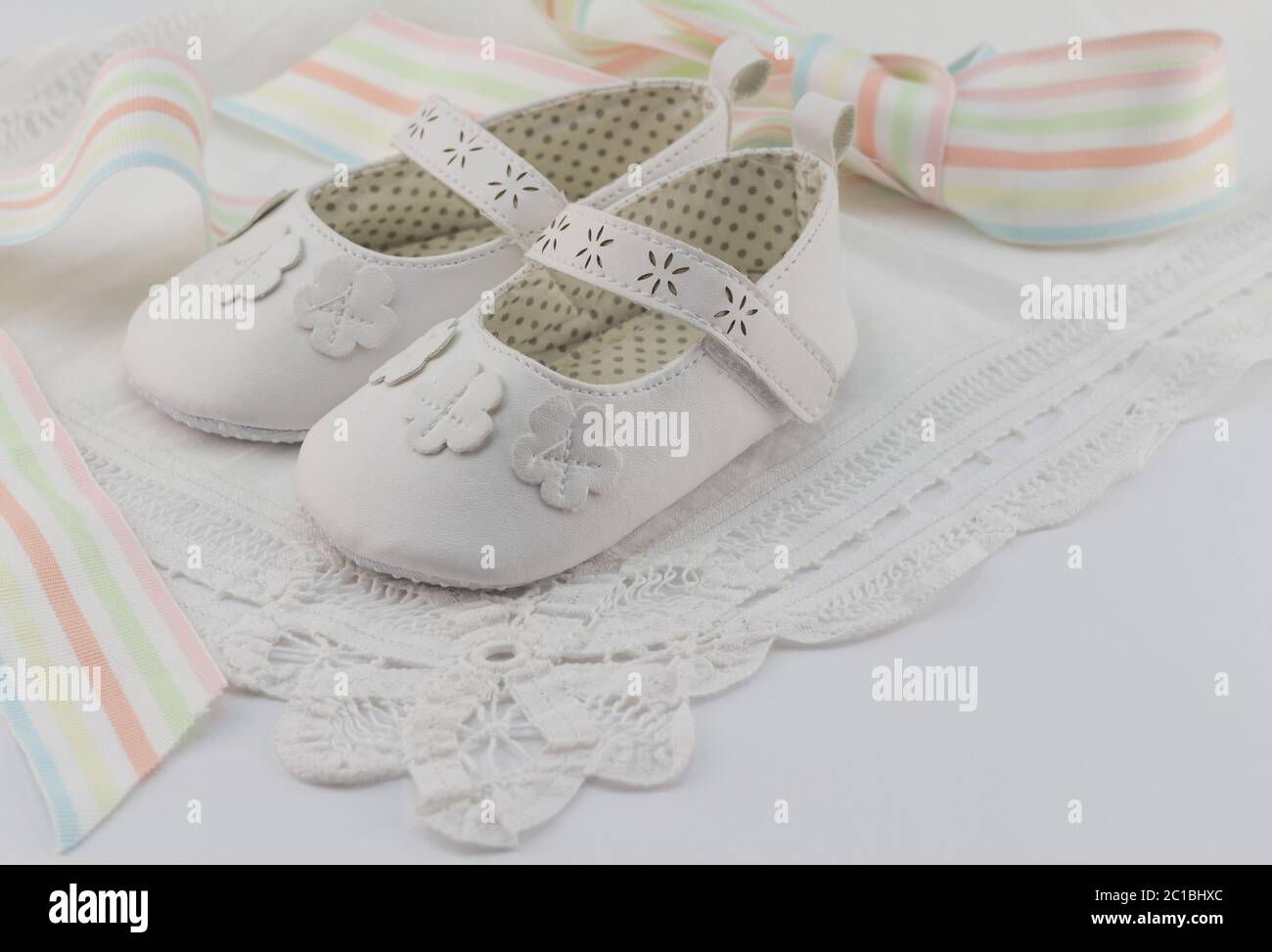 Baby booties background with white lace and pastel colour ribbon ...