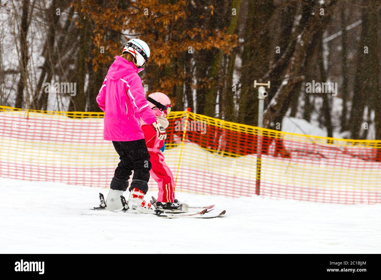 Ski lesson, little girl skiing with an instructor Stock Photo - Alamy