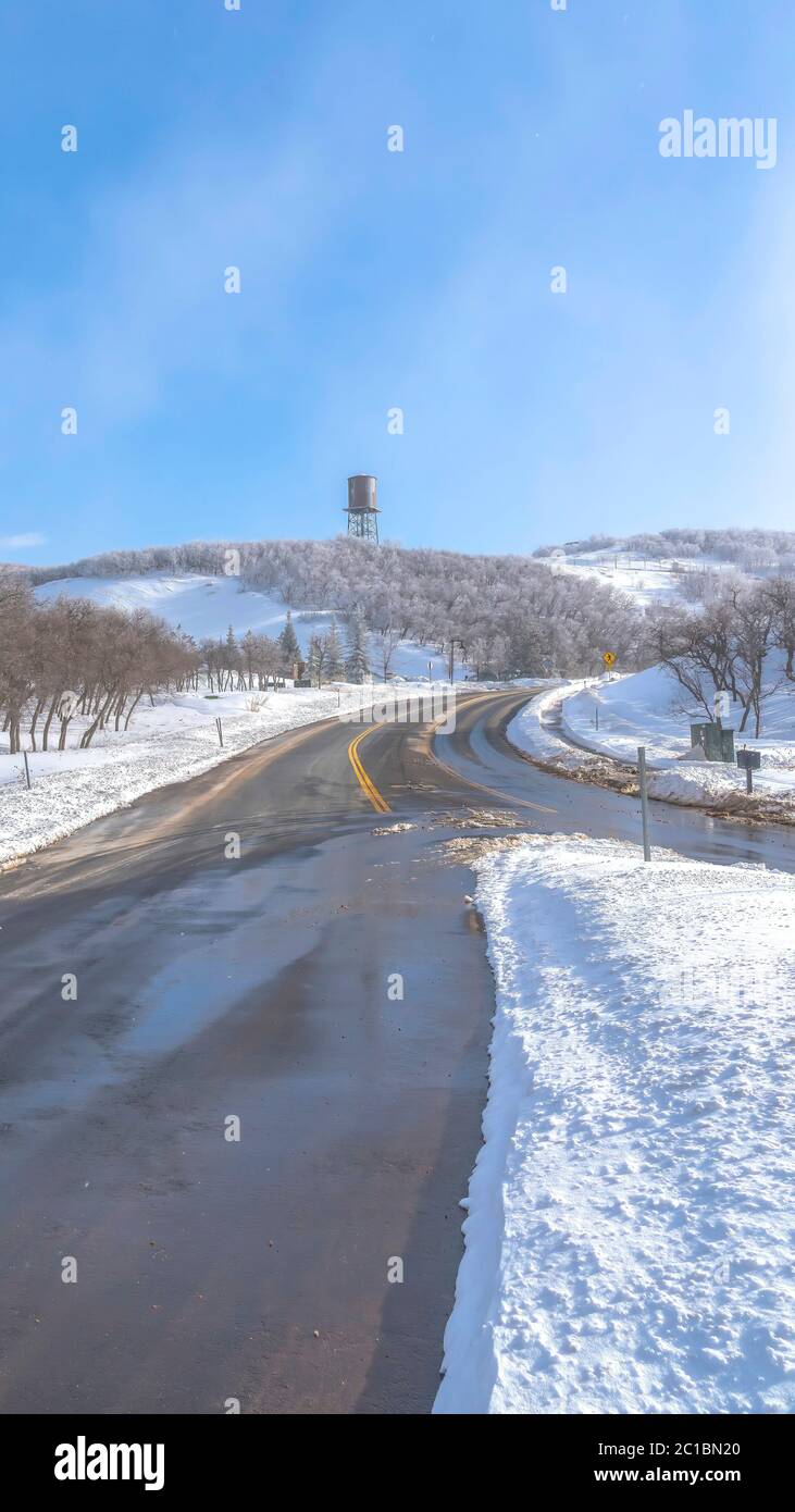 Vertical crop Road on the snowy terrain of Wasatch Mountain with blue ...