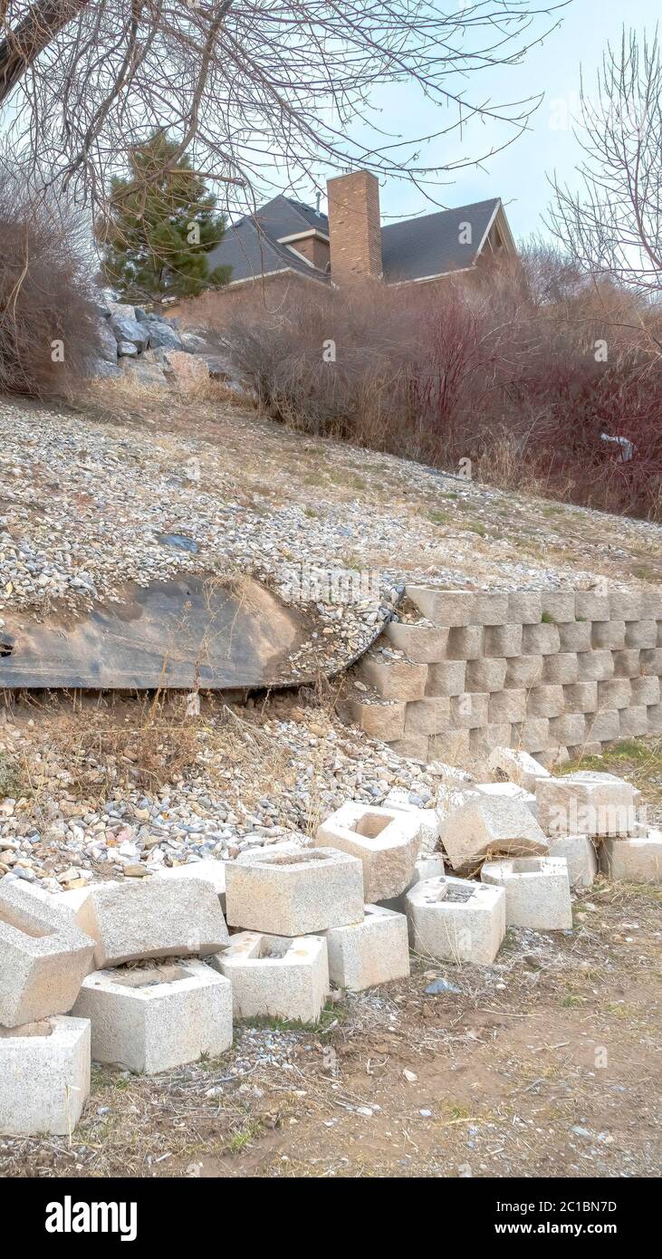 Vertical Stone blocks of collapsed retaining wall holding the soil of a ...