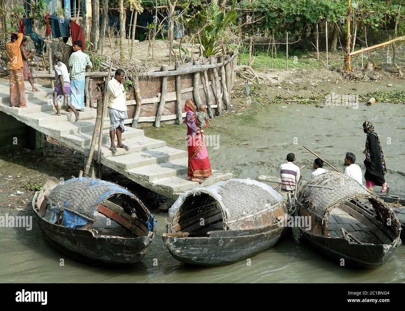 Fishing boats moored at the side of the river in a small town. Waterways of the Ganges Delta in ...