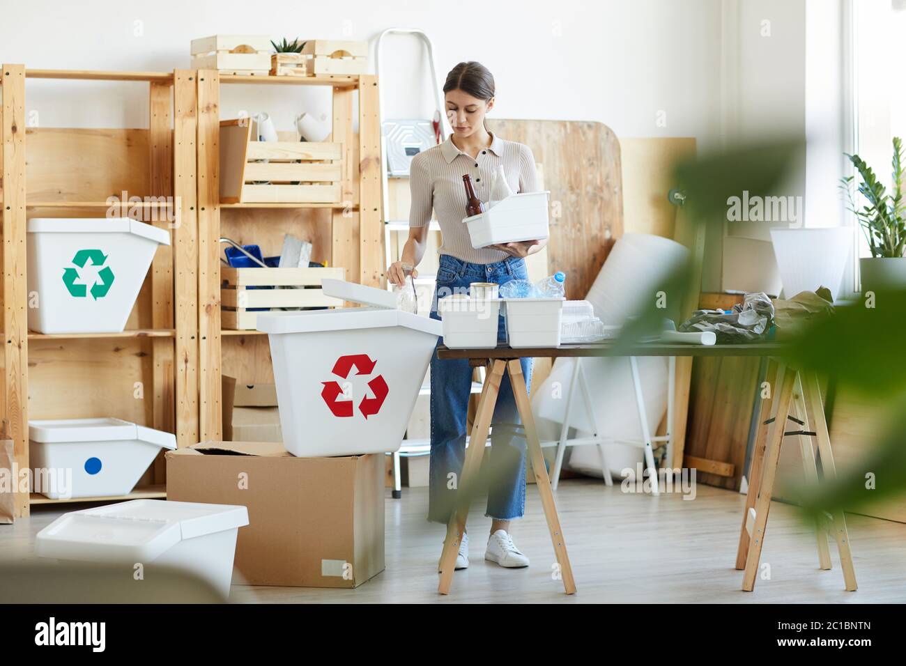 Young woman doing recycling in warehouse she sorting garbage into the ...