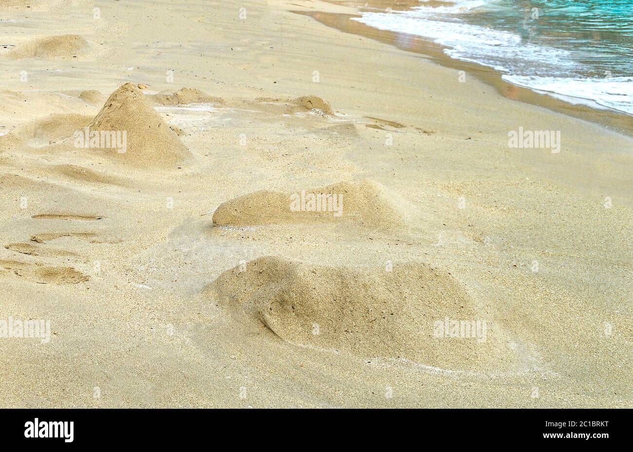 A lot of sand and building houses on the beach, children's creativity ...