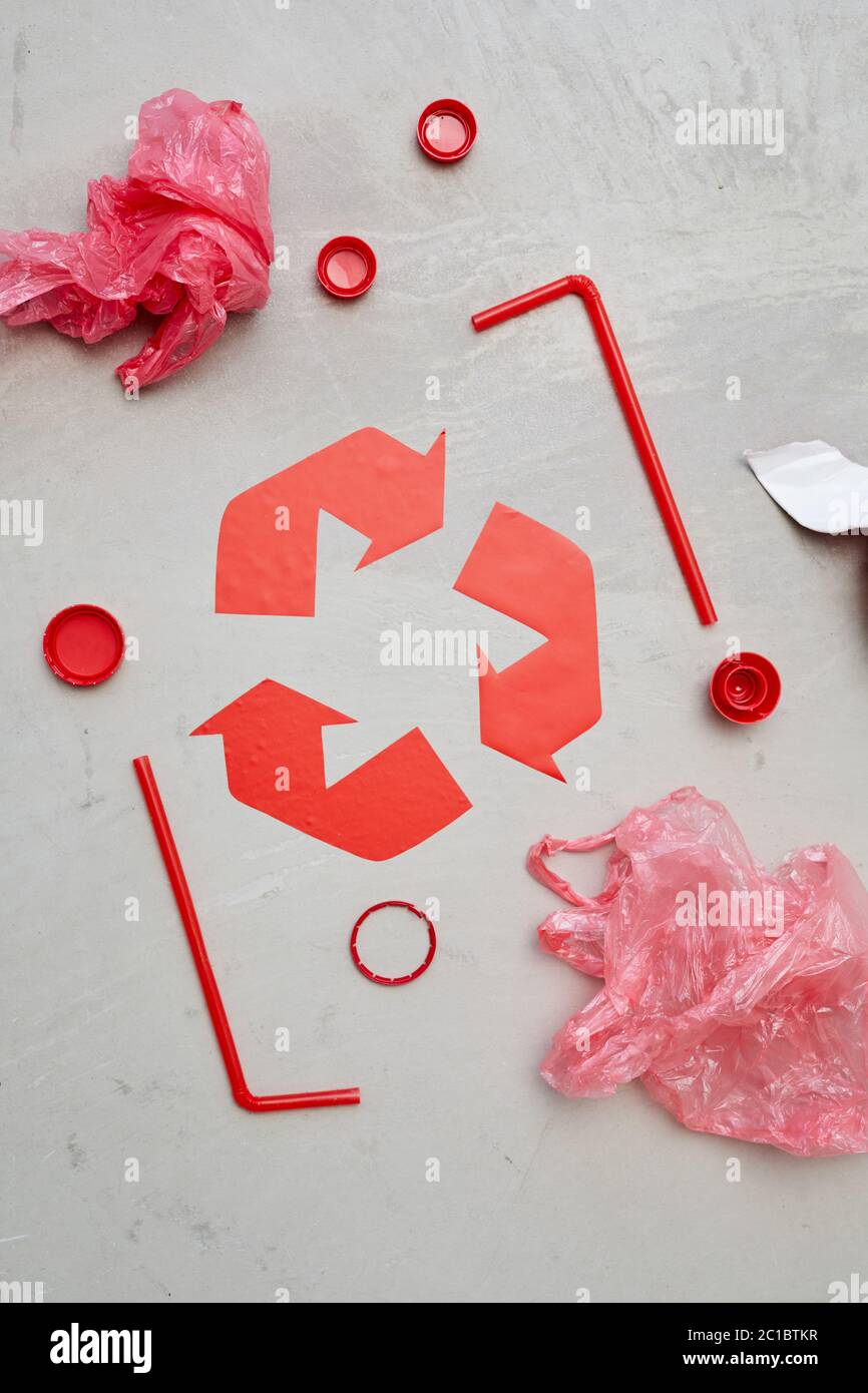 Close-up of red recycling symbol with garbage around it isolated on ...