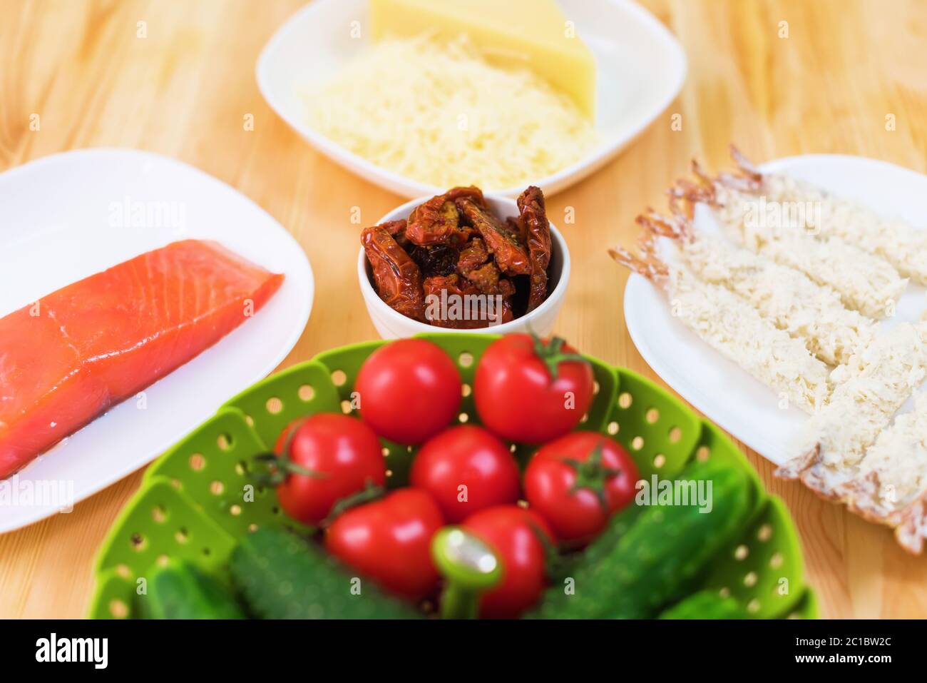 Still life of raw food in white plates on a wooden table. Frozen salmon ...