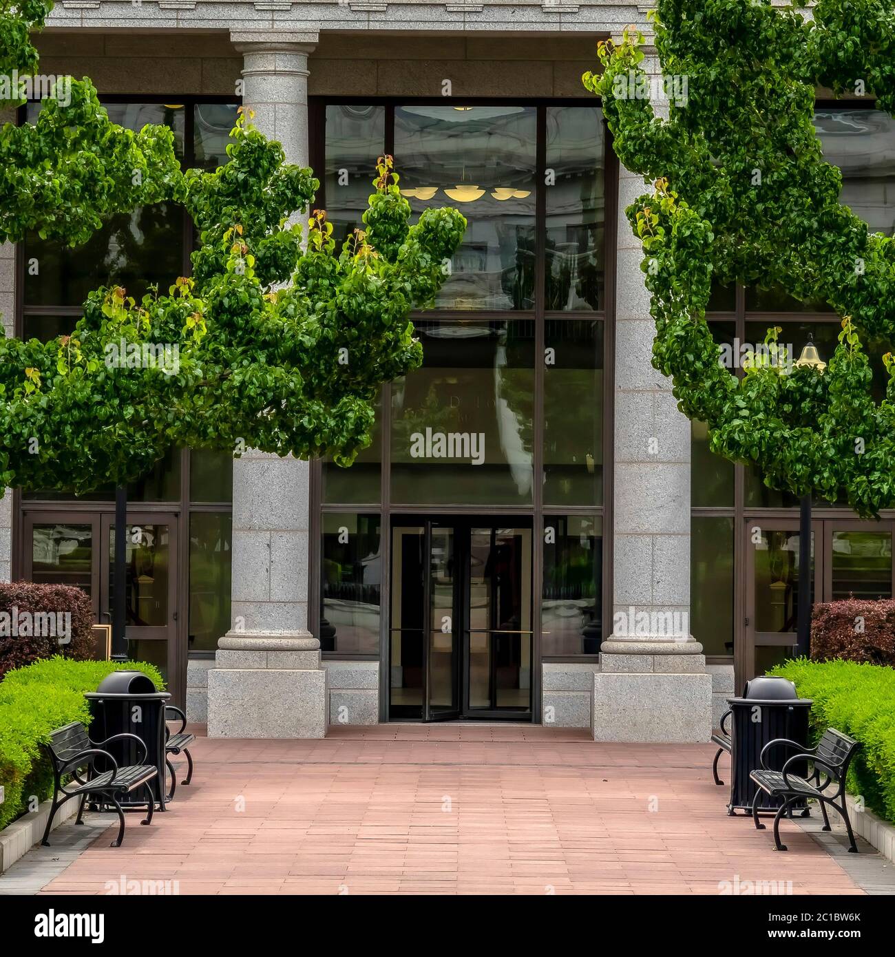 Square frame Entrance to a white building with pavement leading to the ...