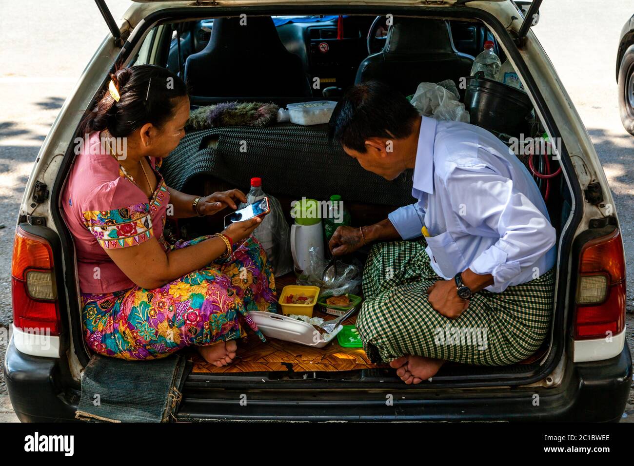 A Couple Share A Meal In The Back Of A Car, Yangon, Myanmar Stock Photo - Alamy