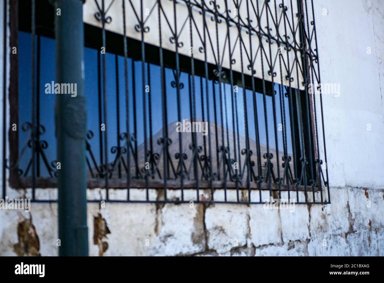 View of El Misti volcano in the window's reflection with bars in ...