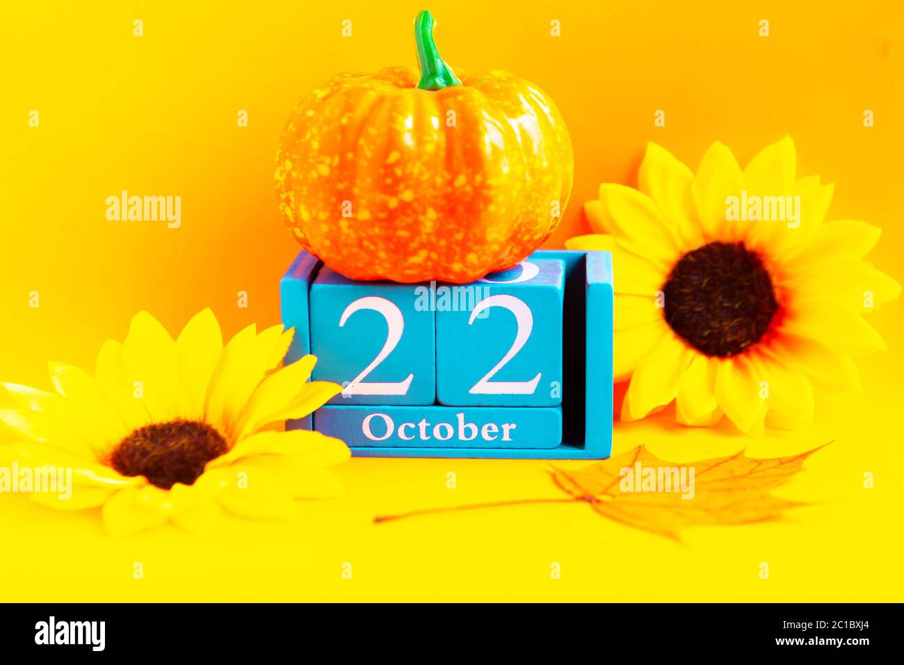 October 22. Wooden cube calendar with month and date on bright orange ...