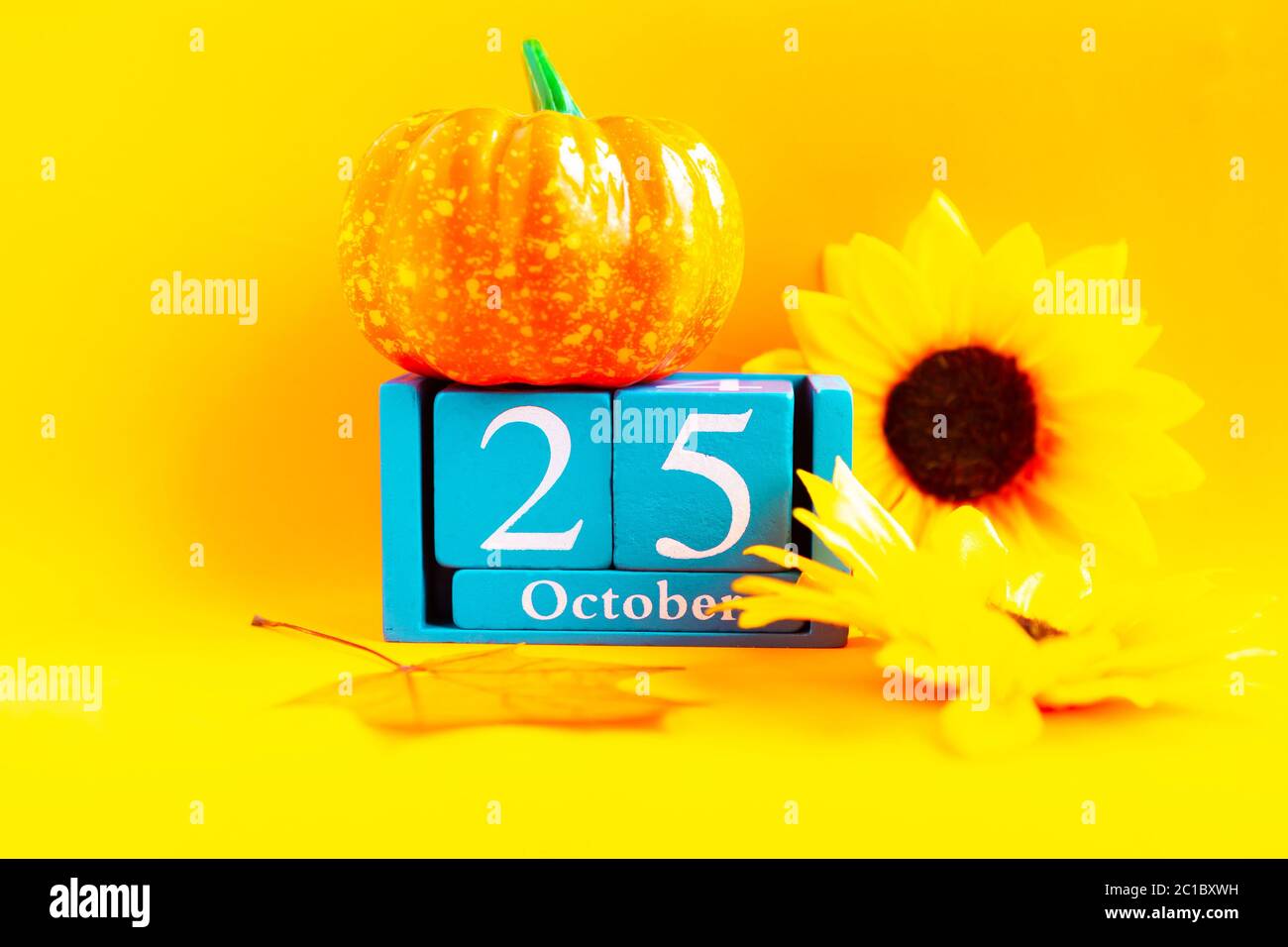 October 25. Wooden cube calendar with month and date on bright orange ...