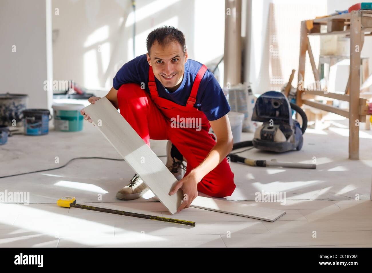 Master is wearing work clothes, is checking horizon of installing tiles ...