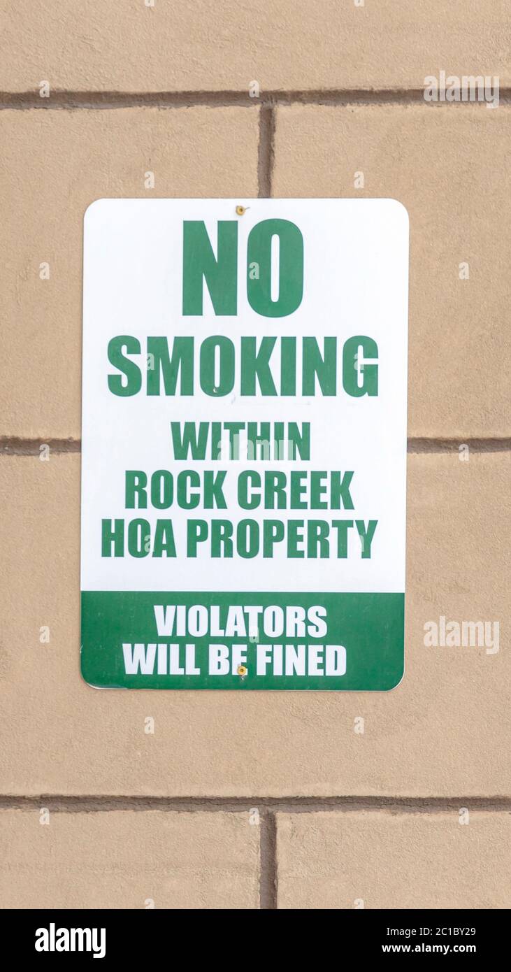 Vertical No Smoking sign on the exterior stone wall of apartment in ...