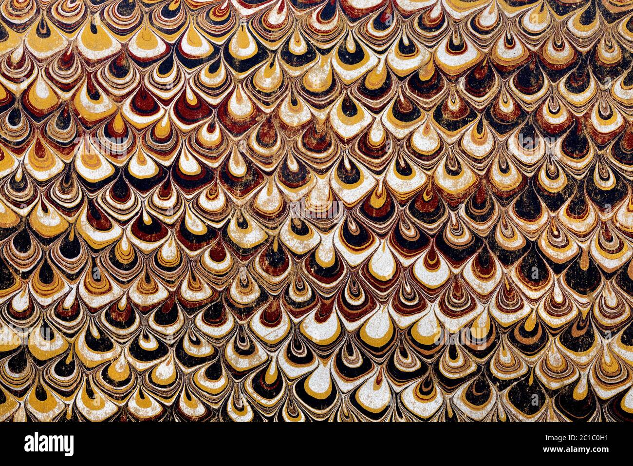 Abstract repetitive pattern of paper marbling on a worn endpaper used ...