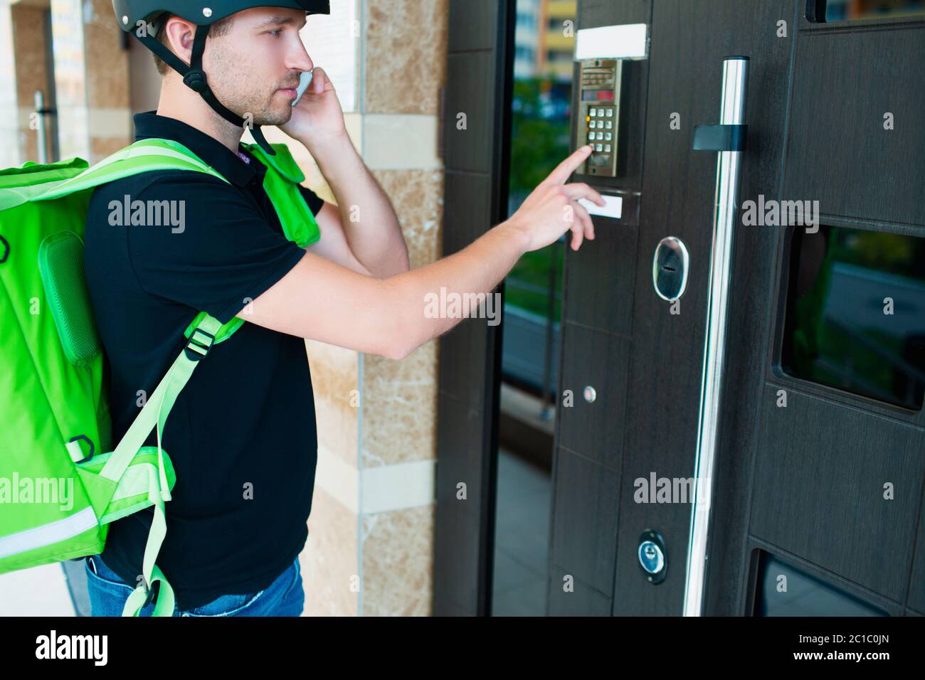 Food delivery concept. Food delivery man ringing on intercom Stock ...
