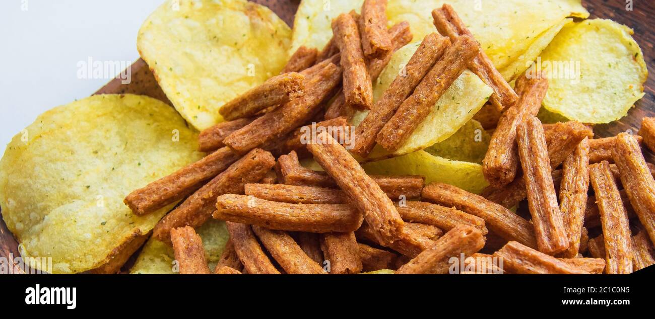 Banner of food and snacks, delicious potato chips and salted rye bread ...
