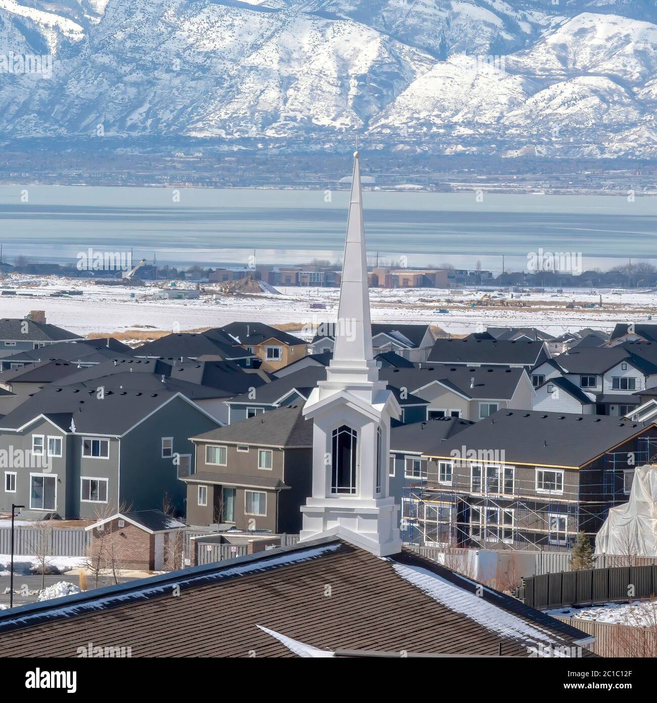 Square frame Church spire against neighborhood homes with snowy ...