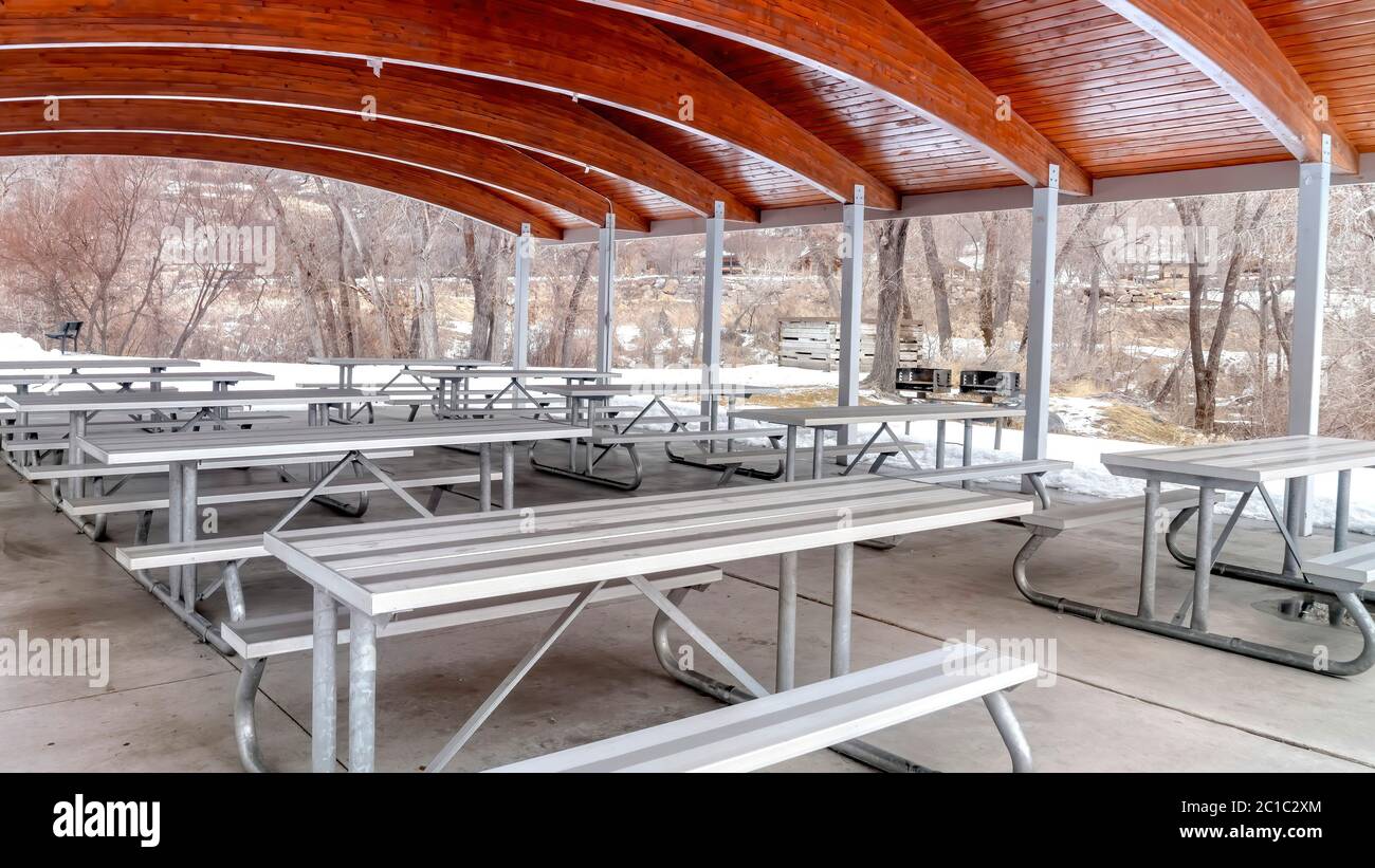 Panorama Tables and benches inside a park pavilion with wooden arches ...
