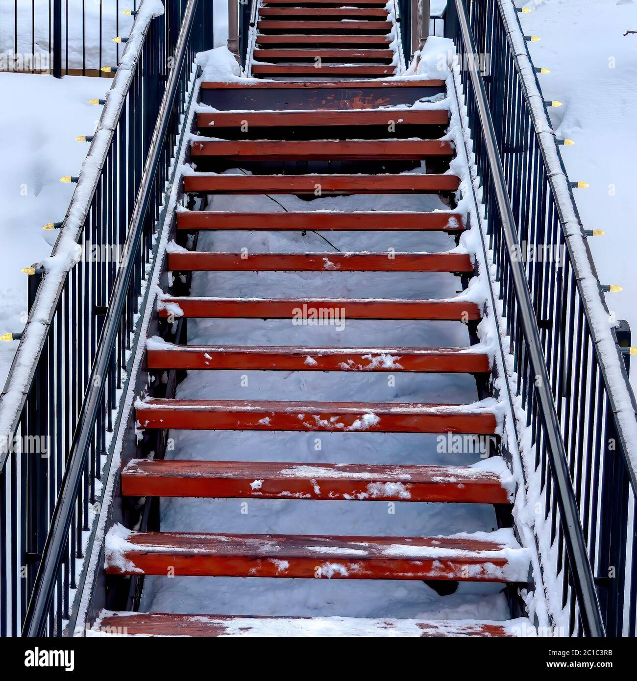 Square Stairway on snowy slope with buildings and trees under overcast ...