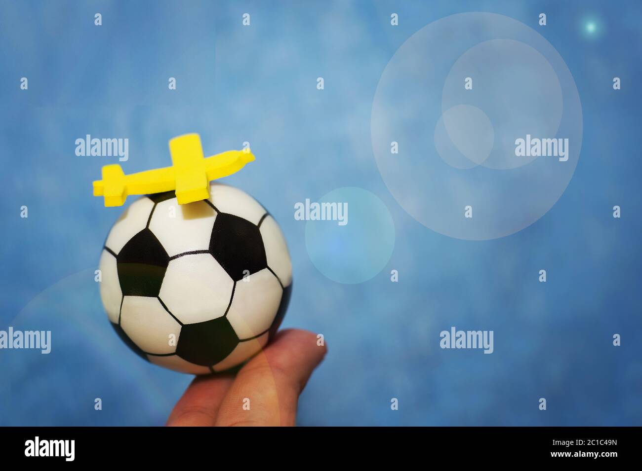 Yellow toy airplane on a soccer ball. The concept of flying to the ...