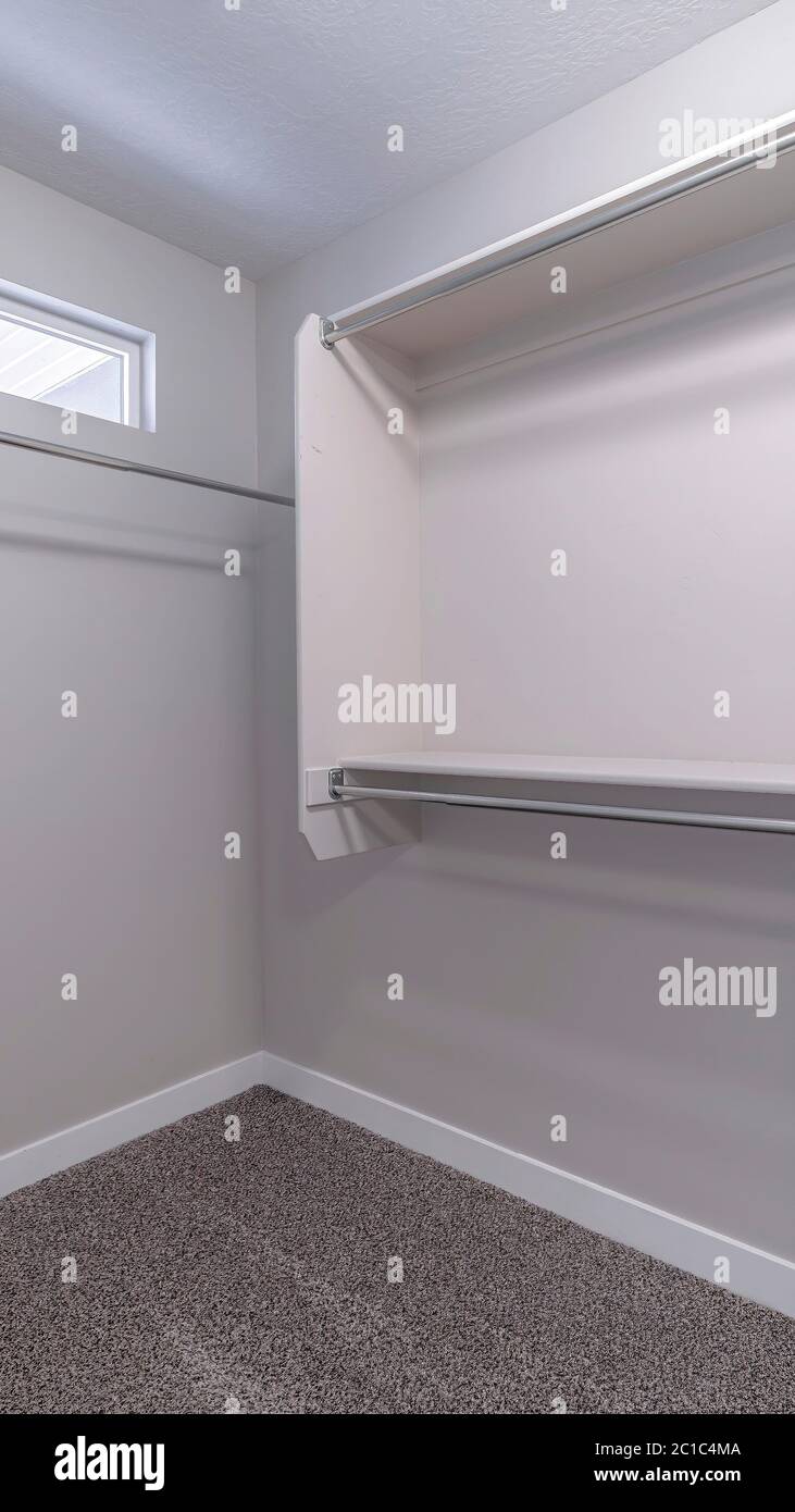Vertical Empty walk in closet interior with small window carpet floor ...