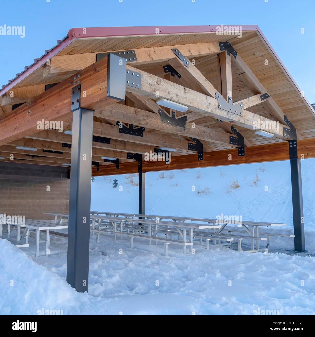 Square Pavilion attached to a small building at the snowy slope of ...