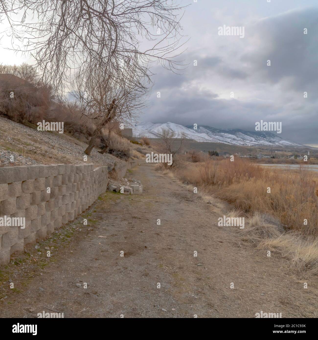 Square Dirt road along the retaining wall of slope overlooking lake and ...