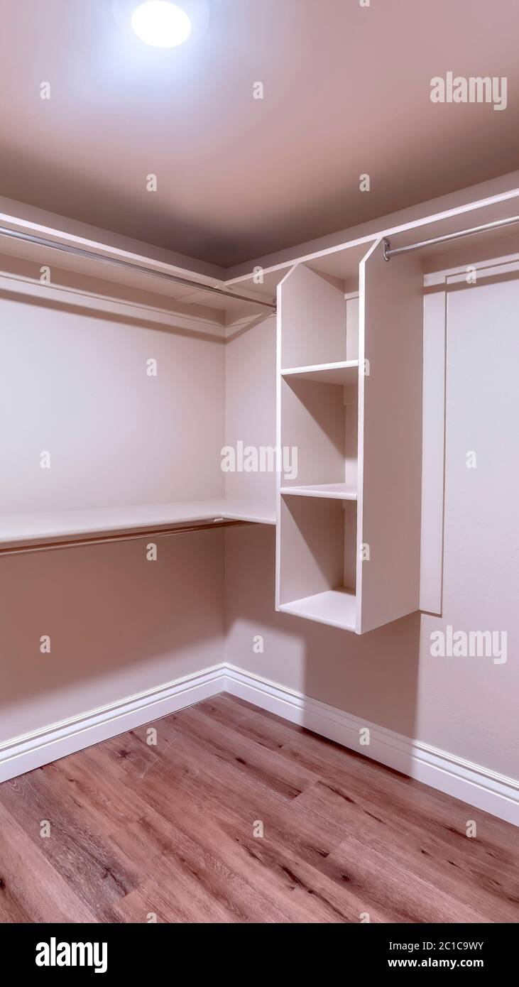 Vertical Spacious walk in closet of new home with metal rods shelves ...