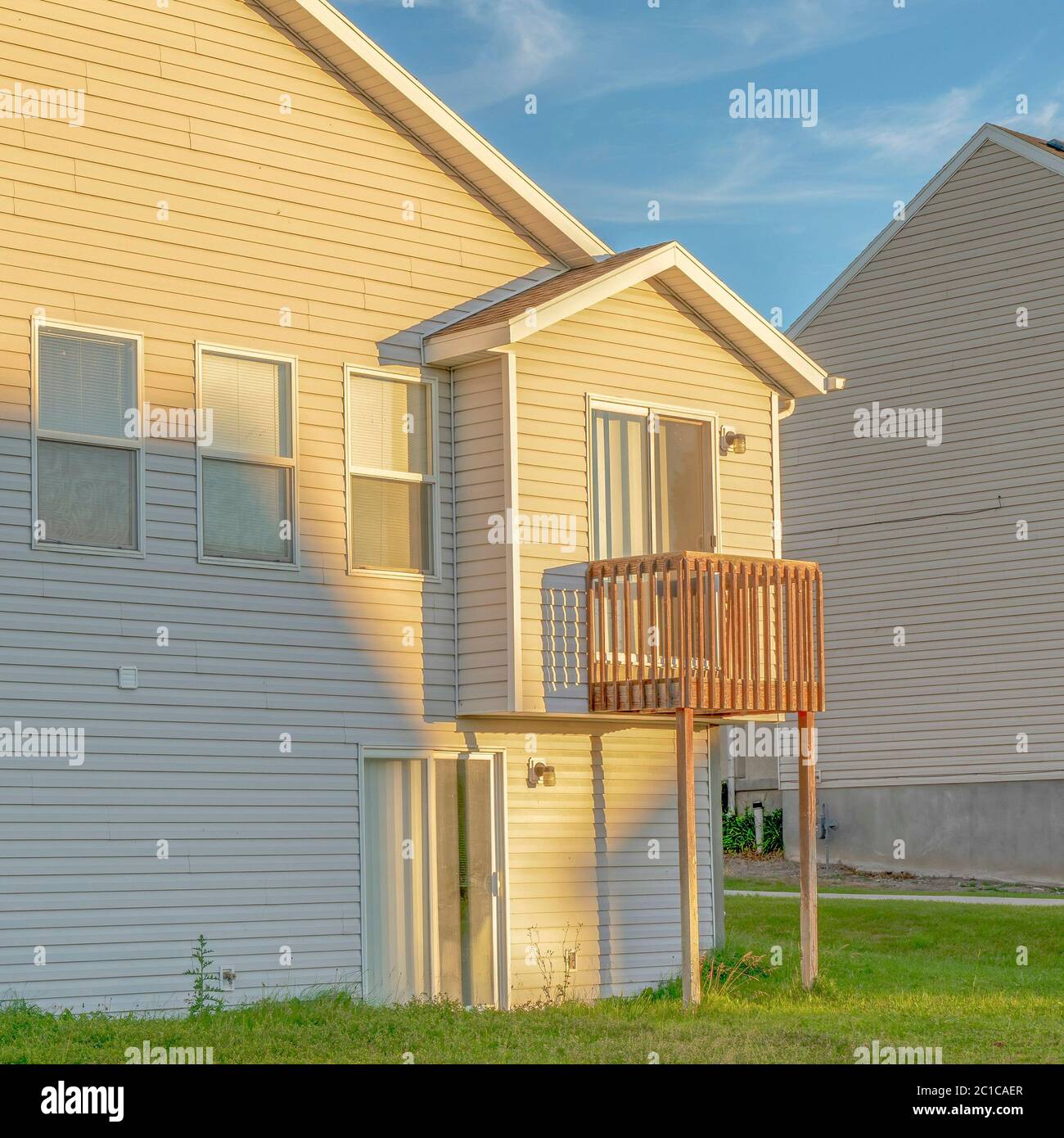 Square Home with white wall siding gable roof and small balcony viewed ...