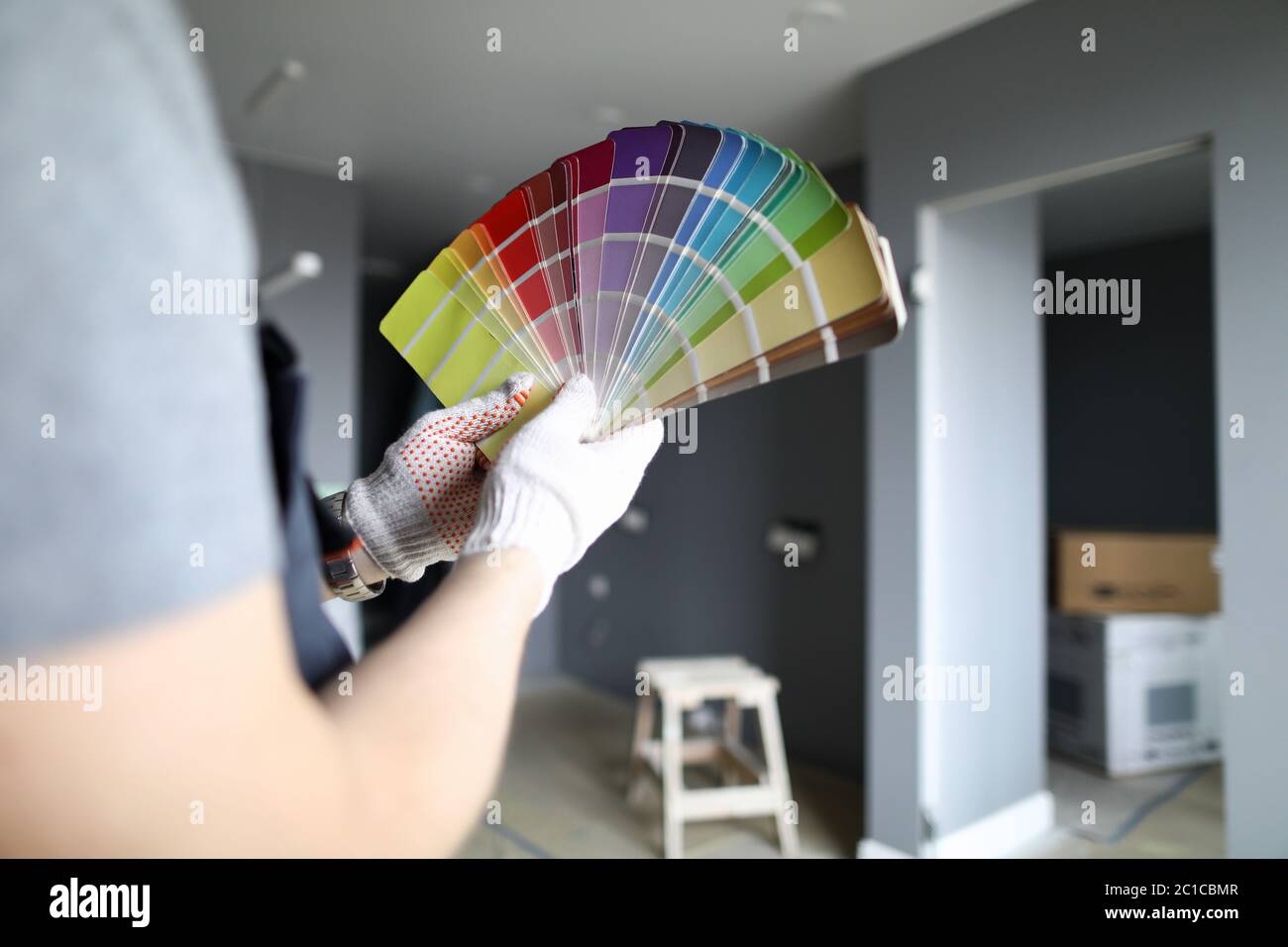 Man holds palette in choosing color for repair Stock Photo - Alamy