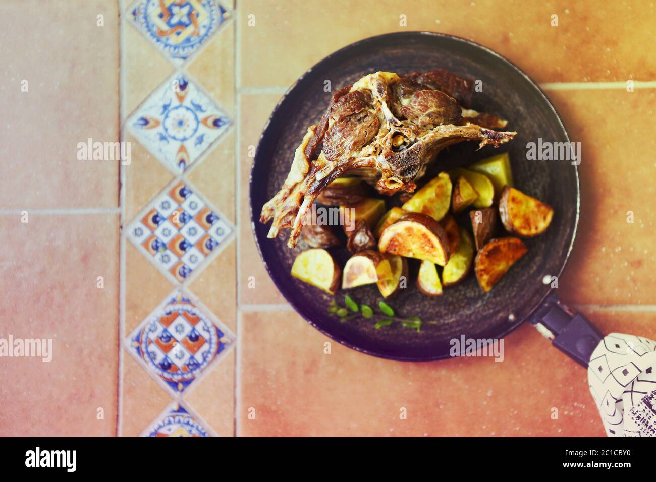 Braised goat meat with sauce and roasted potatoes in the pan Stock ...