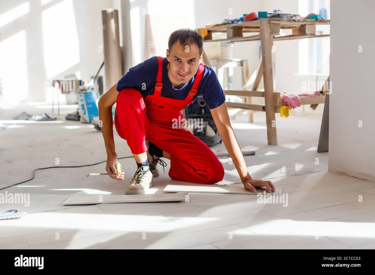 Master is wearing work clothes, is checking horizon of installing tiles ...