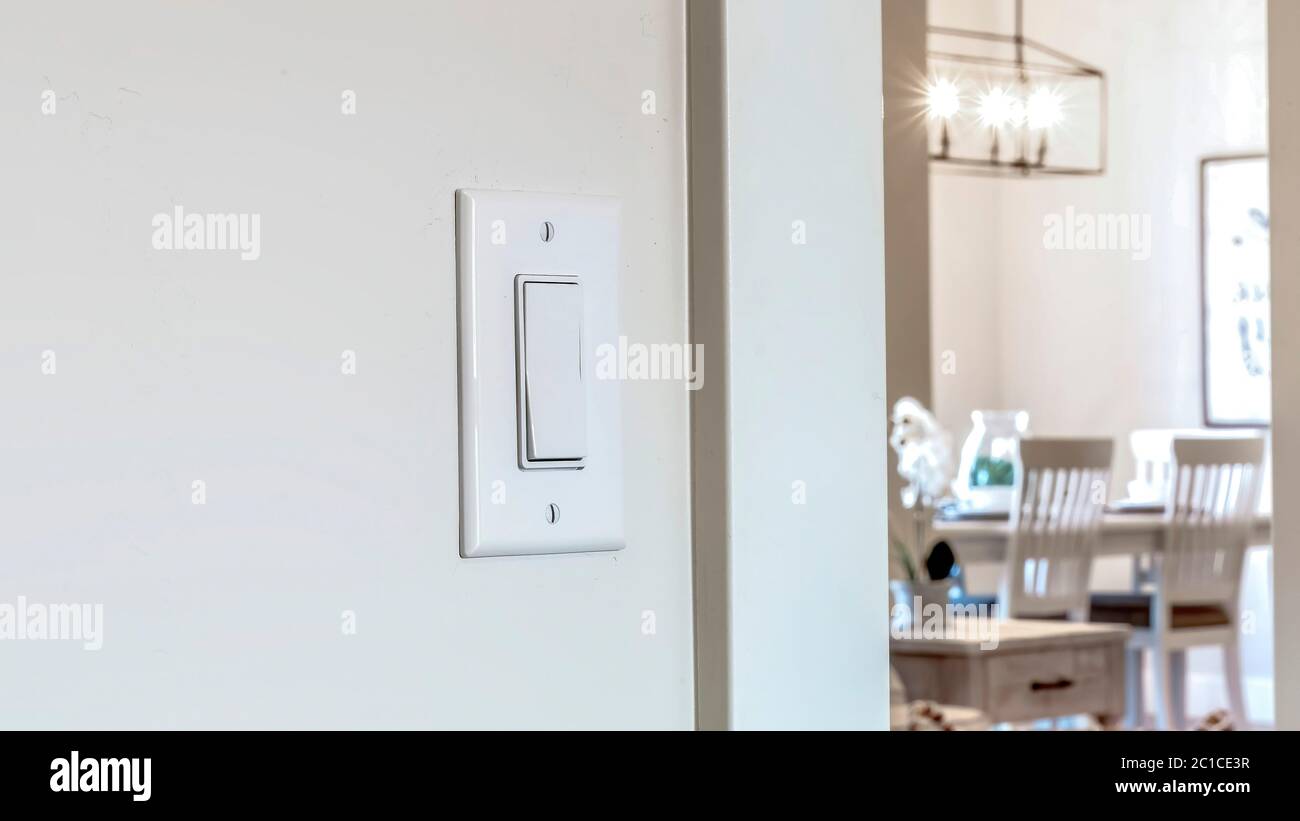 Panorama crop Wall mounted electrical rocker light switch with blurry ...