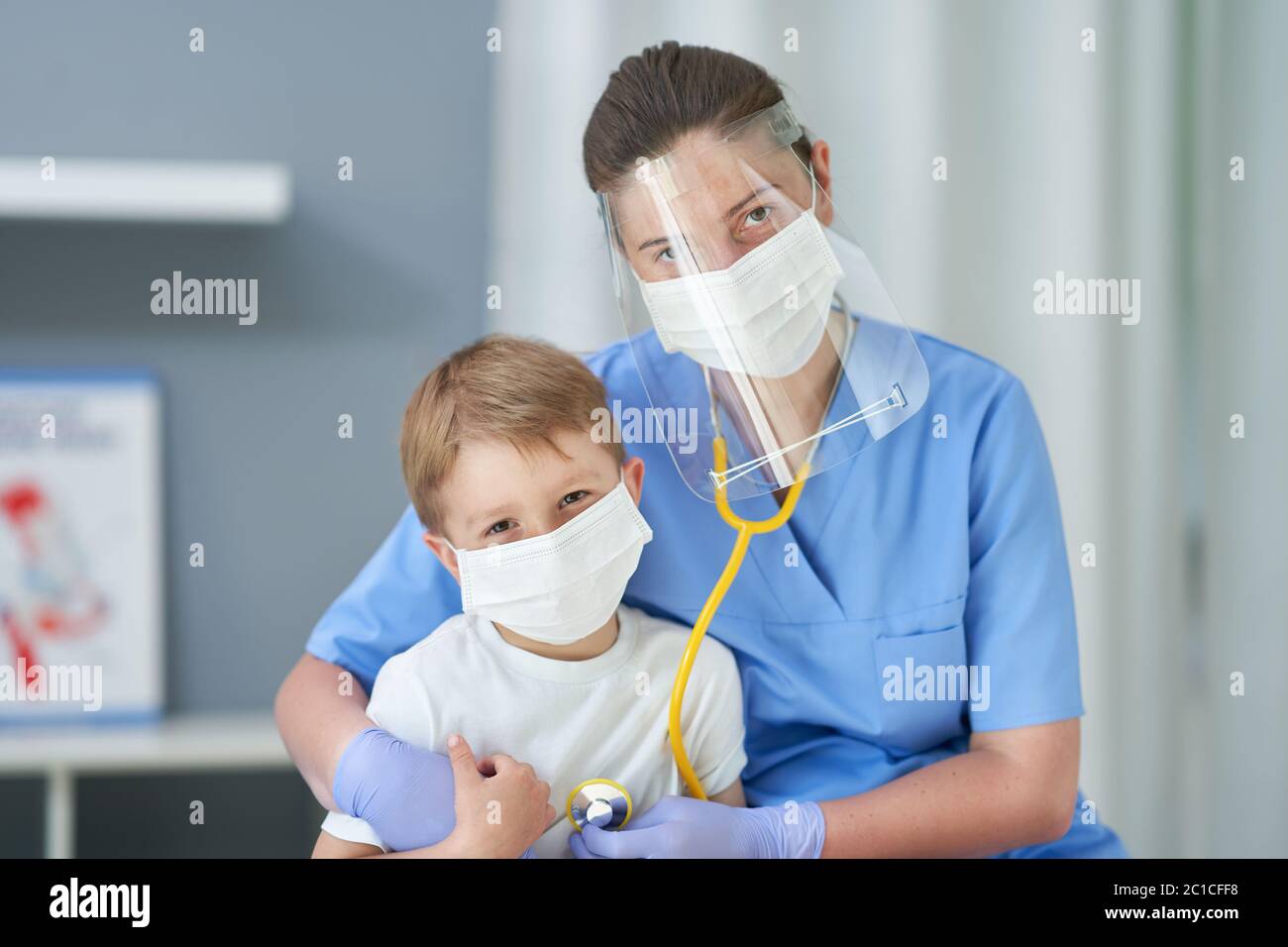 Portrait of adorable little boy being tested by doctor with stethoscope ...