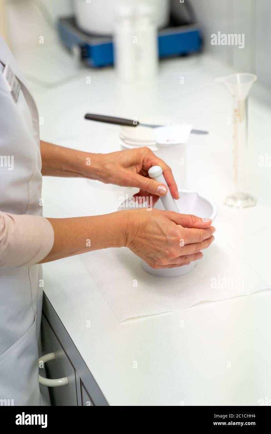A close up view of a pharmacist in the laboratory mixing a medical ...