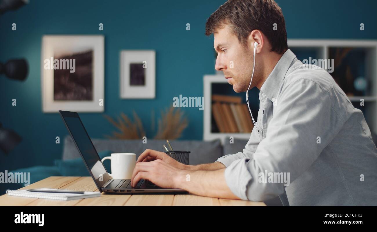 Serious man using laptop, side Stock Photo - Alamy