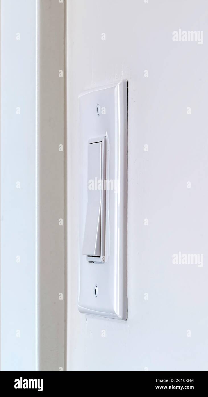 Vertical Side view of electrical rocker light switch mounted on white ...