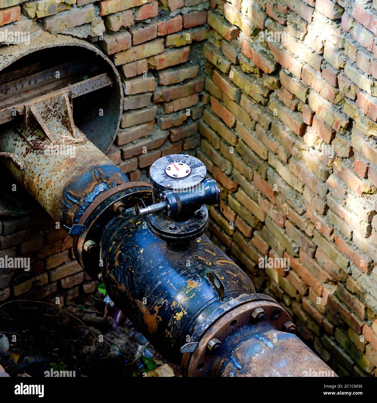 An open underground pipeline with valves in a brick well. Underground ...