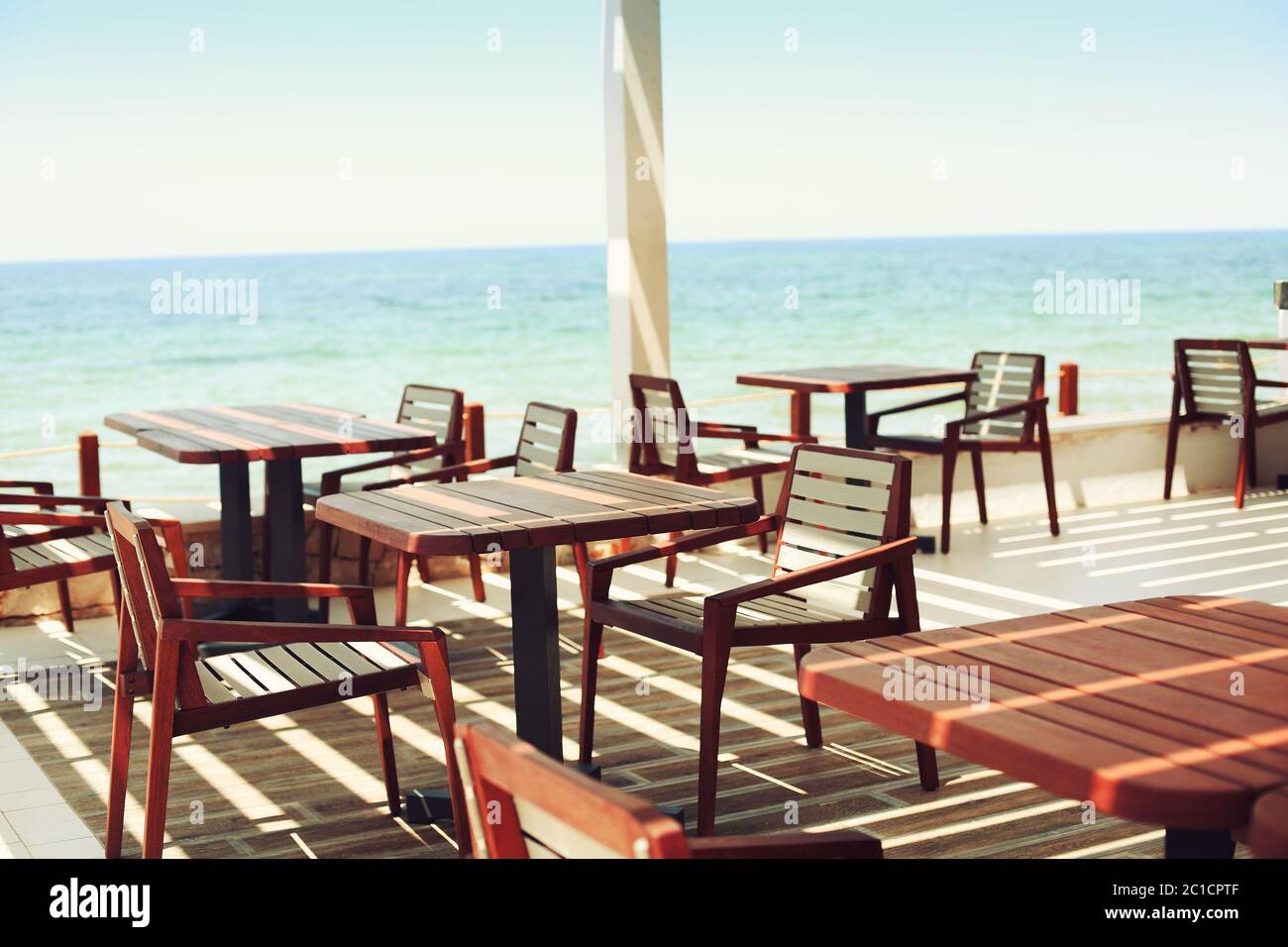 Tables and chairs at outdoor restaurant on the beach Stock Photo - Alamy