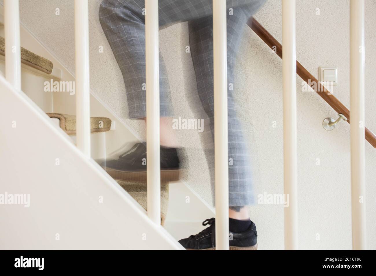 Young adult person walking up the stairs in house Stock Photo - Alamy