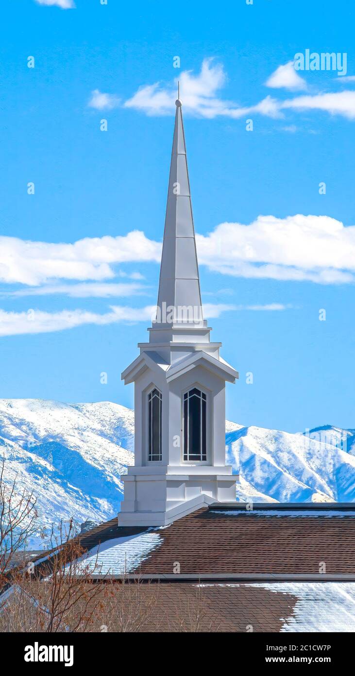 Vertical Rooftop of church with a modern spire design against snowy ...