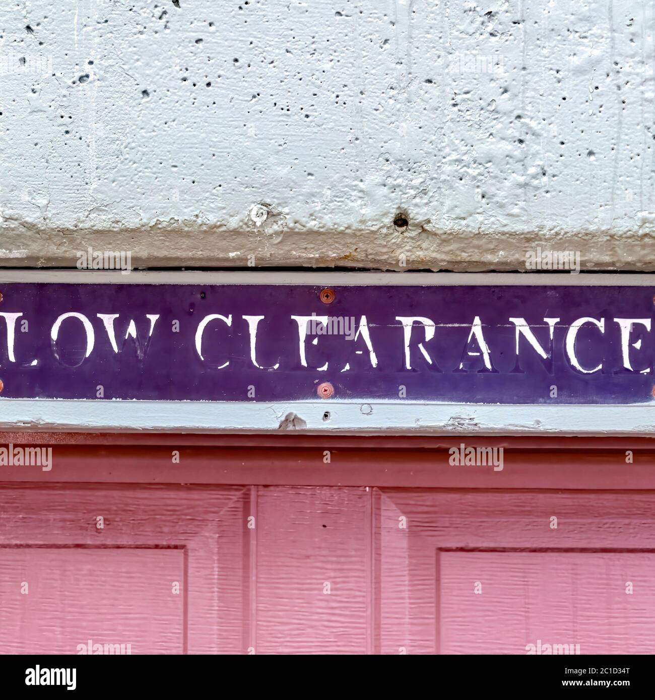 Square crop Low Clearance sign above the panelled red wooden garage ...
