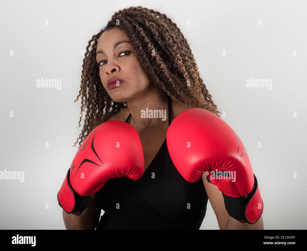 Horizontal portrait of an Afro American woman wearing red boxing gloves ...