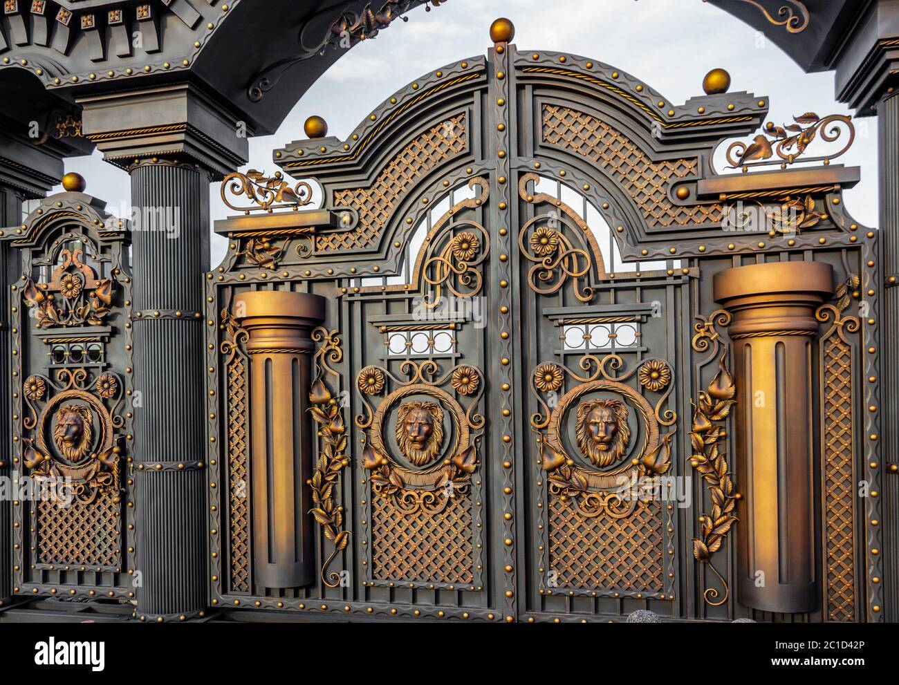 New forged metal massive gates with a wicket and two arches, golden ...