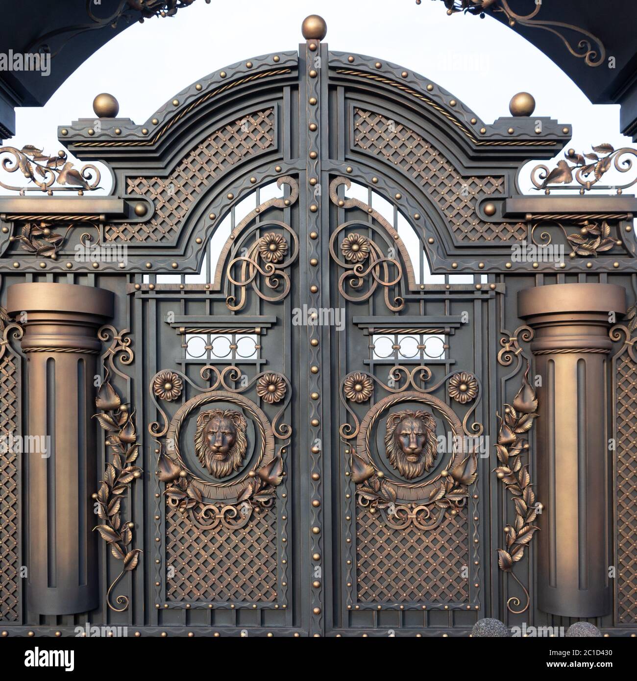 New forged metal massive gates with a wicket and two arches, golden ...