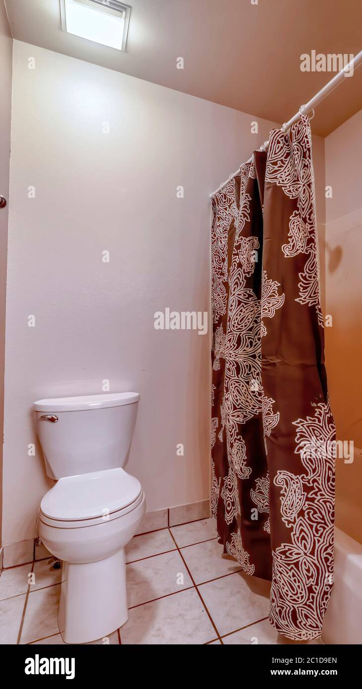 Vertical frame Toilet and bathtub inside bathroom with tile floor and ...