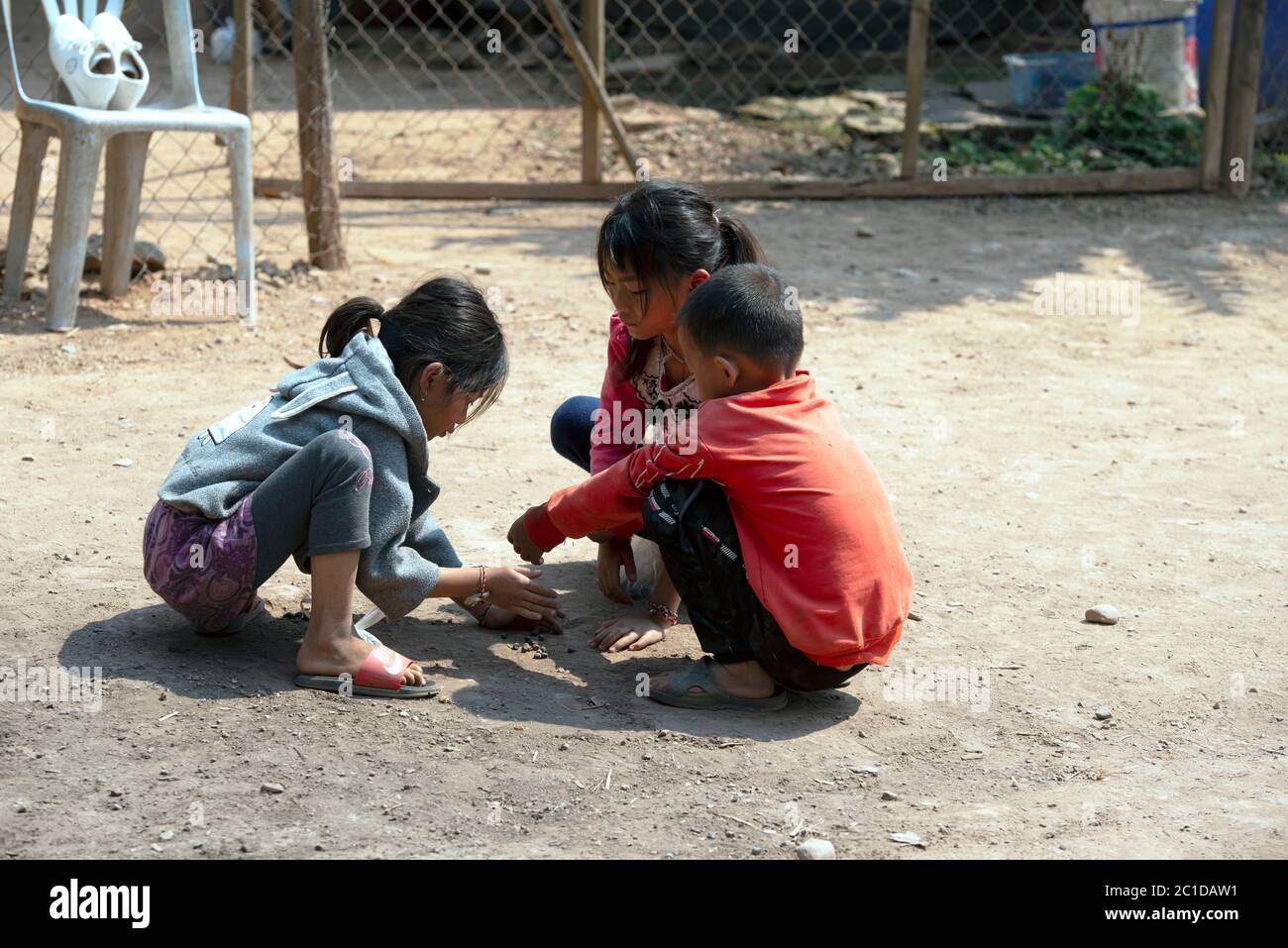 Young, indigenous, ethnic Hmong children playing marbles in their ...