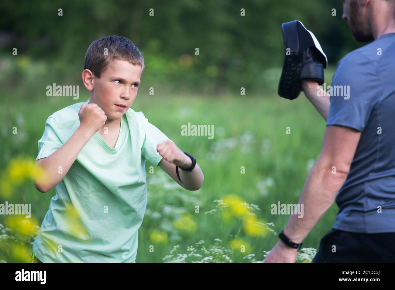 Father and son training to box in the park outdoors, fighting, care ...
