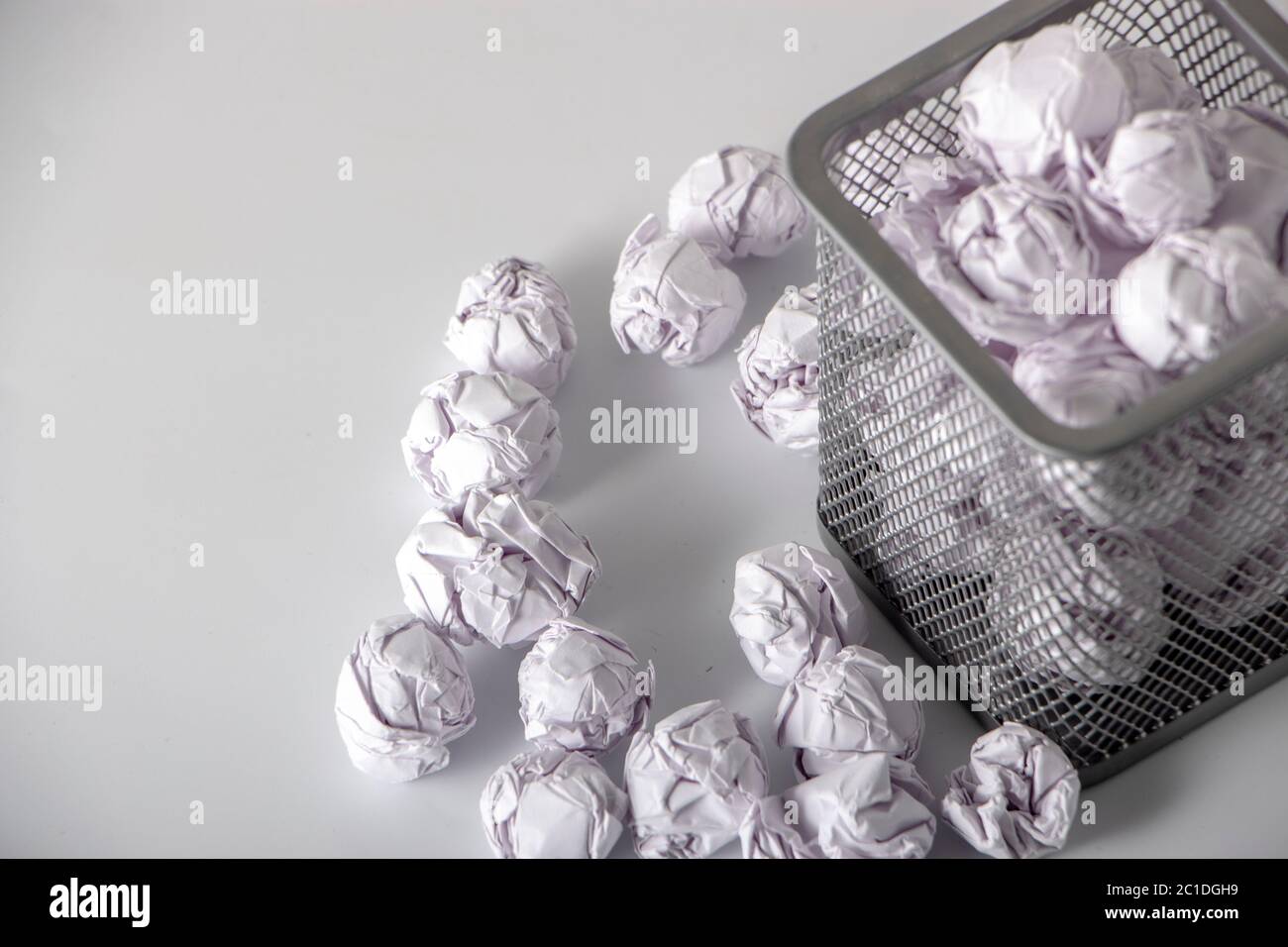 A trashcan full of crumpled paper on white background close up Stock ...