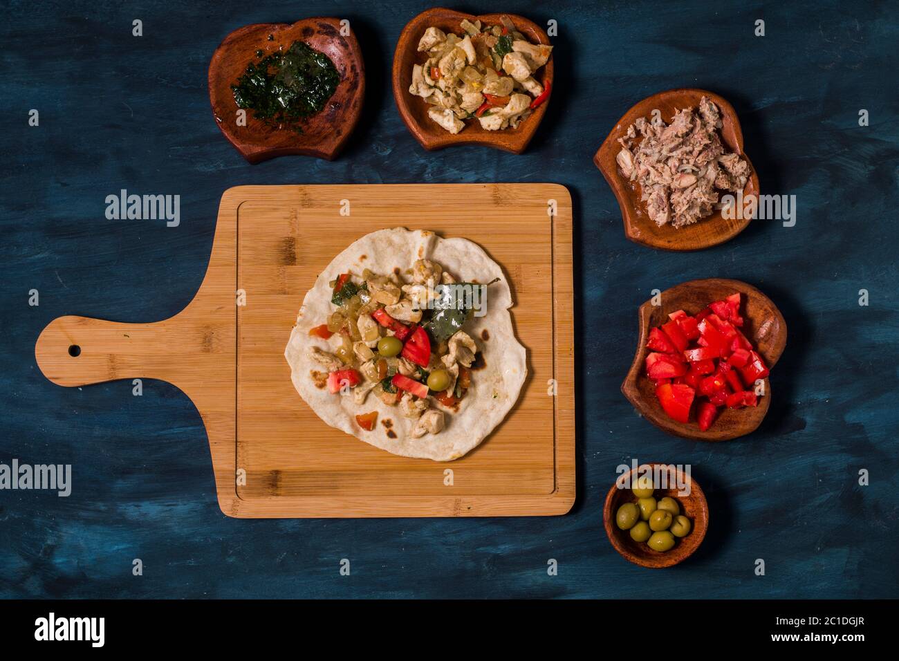 A piadina with chicken and other vegetables on a blue table Stock Photo ...