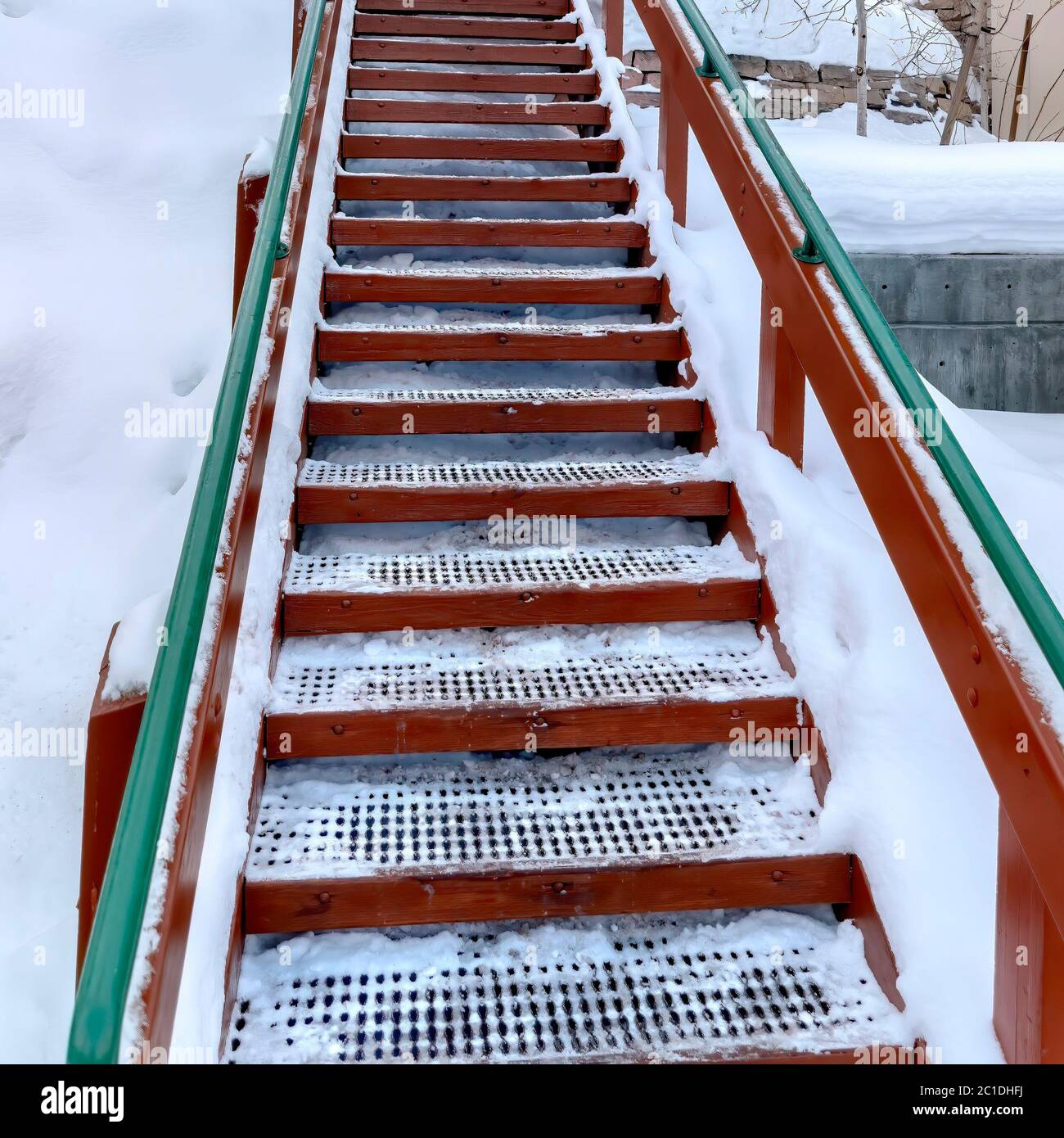 Square Outdoor stairs with grate metal treads and green handrail on ...